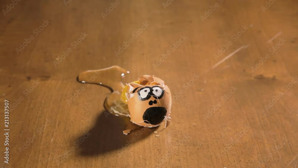 Smashing an egg with a drawn horrified face, killing it. Symbolic ...