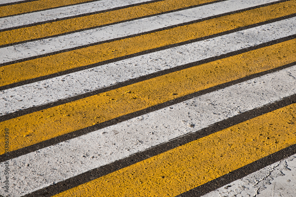 Yellow and white road marking of the pedestrian crossing, close-up ...