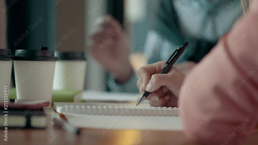 Close up hands of european woman taking notes in notepad using pen on ...