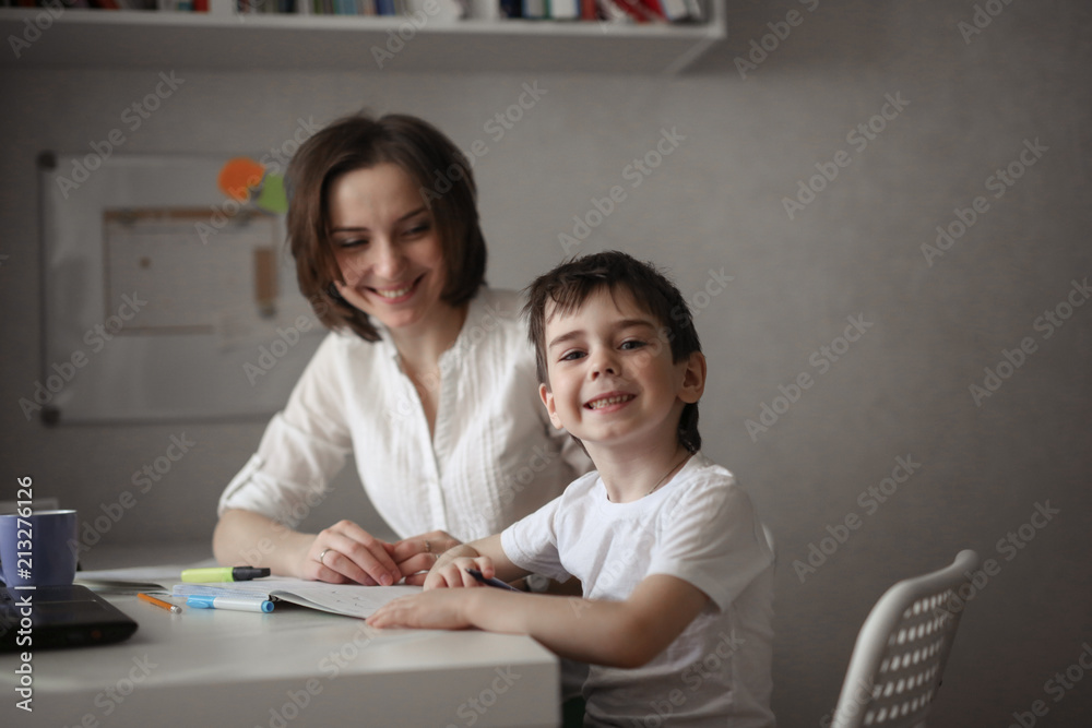 beautiful mother teaches her son at home at table Stock Photo | Adobe Stock