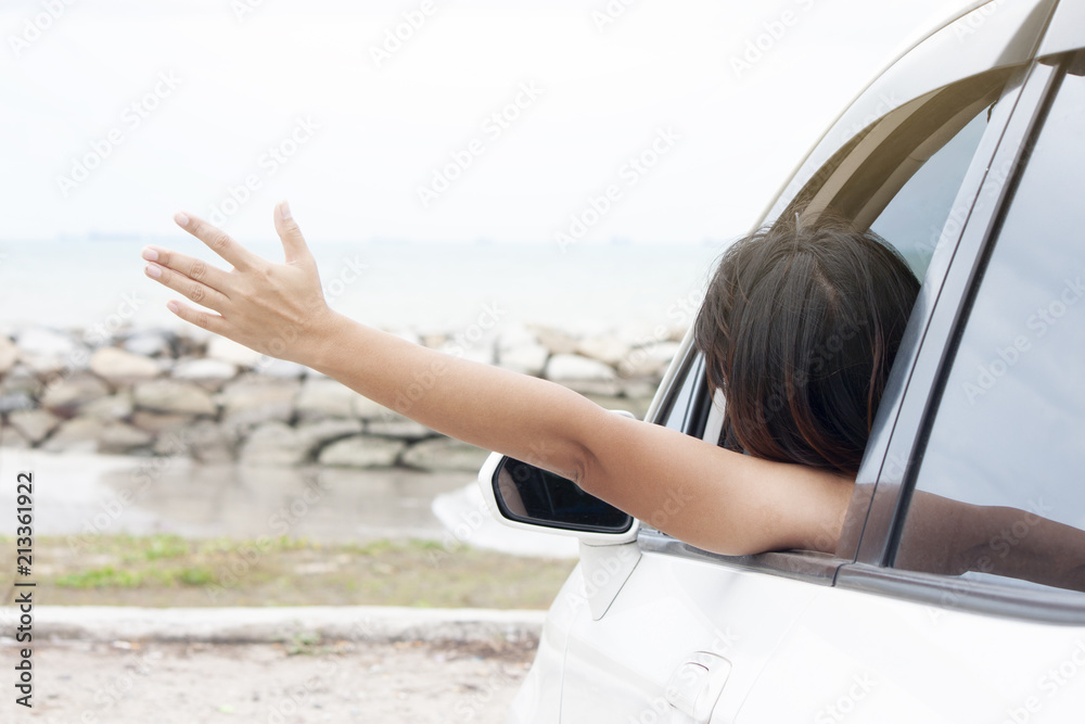 Car girl woman summer vacation on road trip waving out the window. Back ...