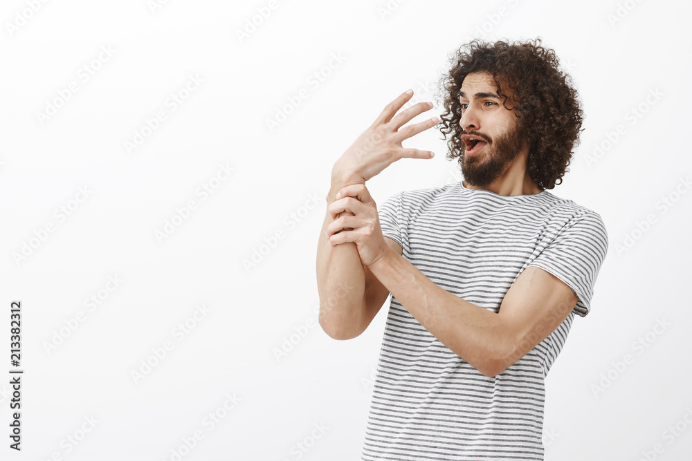 Someone controlling his arm. Funny playful handsome male with curly ...