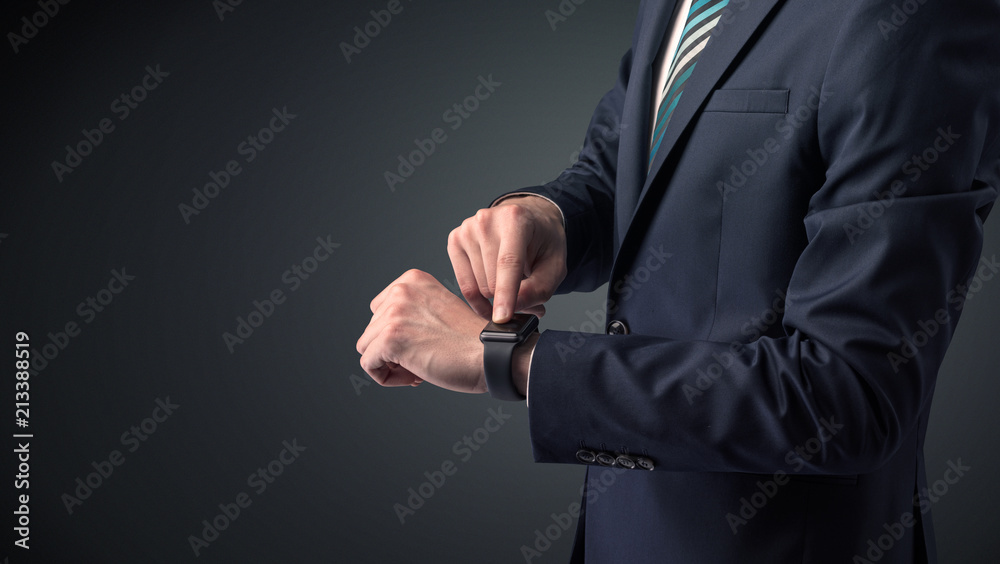 Man wearing suit with smartwatch on his wrist. Stock Photo | Adobe Stock