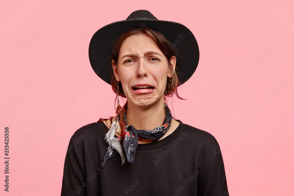 Photo of sorrowful female cries as has grief, purses lips and has ...