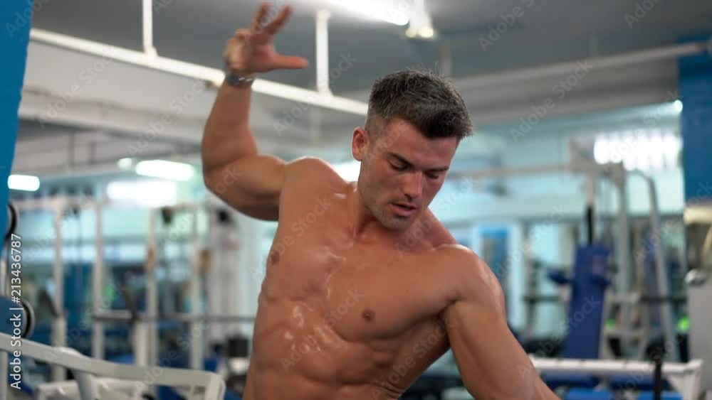 Perspiring man demonstrating his muscular body after exhausting ...