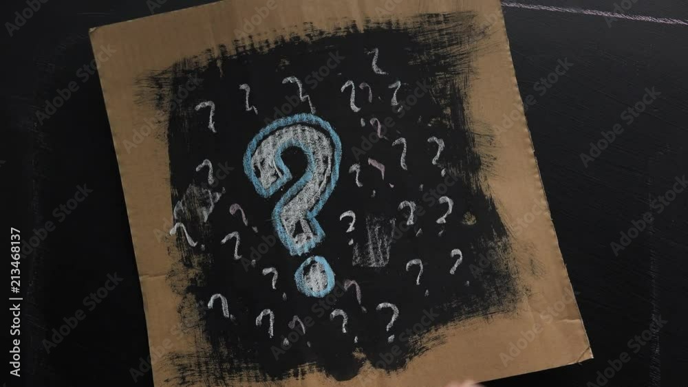 Hand sketching question marks on cardboard paper, concept of perplex ...