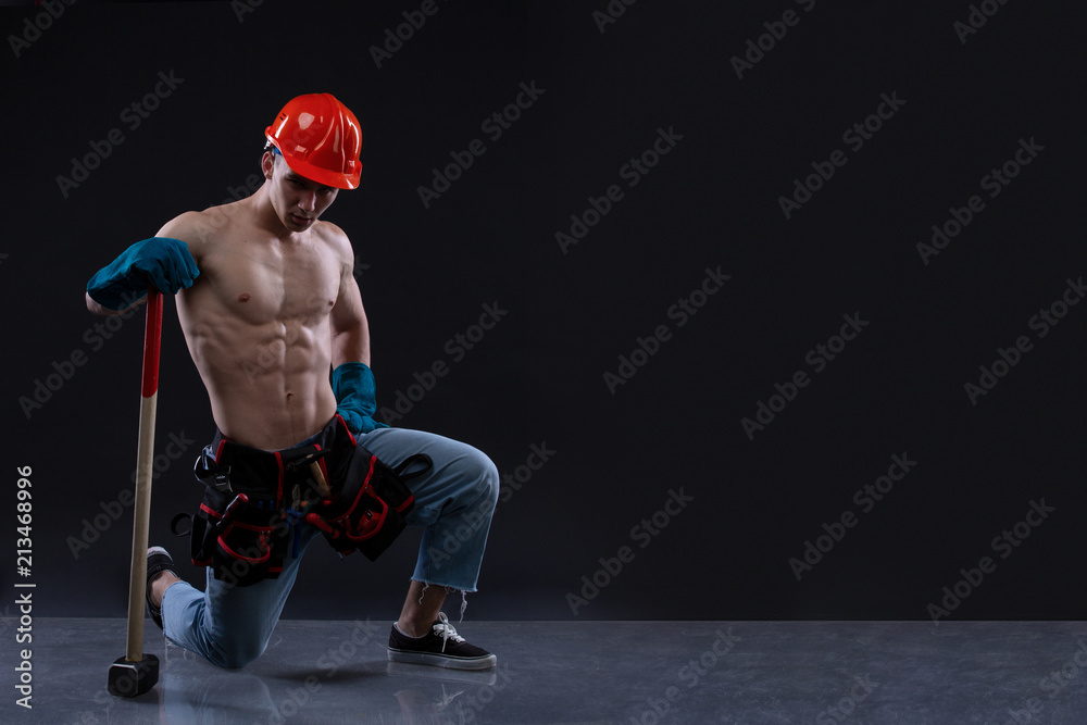 Handsome young topless construction worker with sledge hammer, studio ...