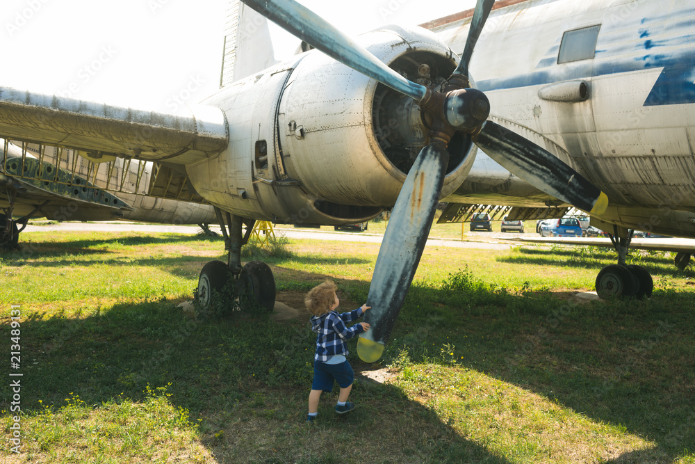 Boy starts the plane. Big wings of plane and little boy with dream of ...