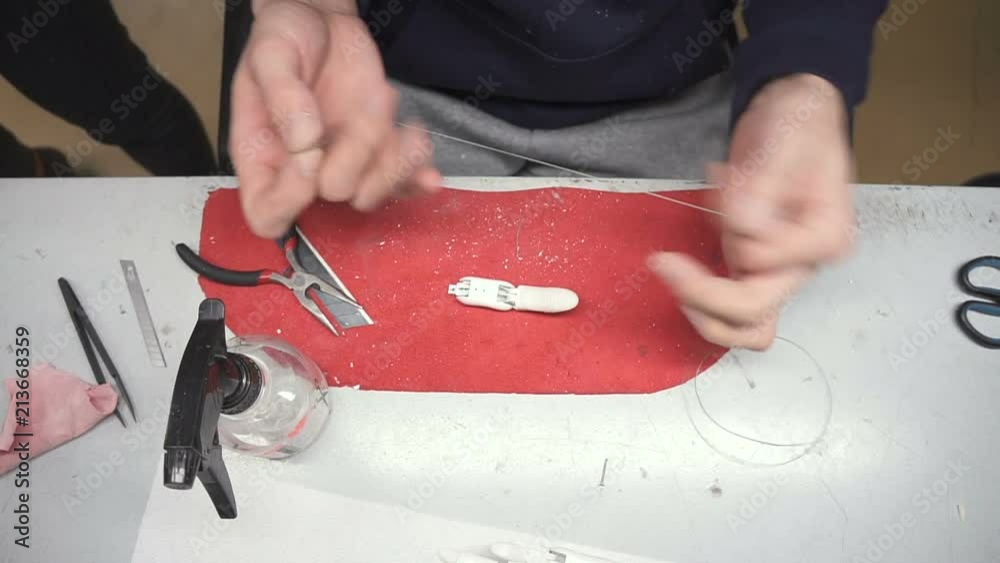 Specialist is assembling traction hand prosthesis sitting at table in ...