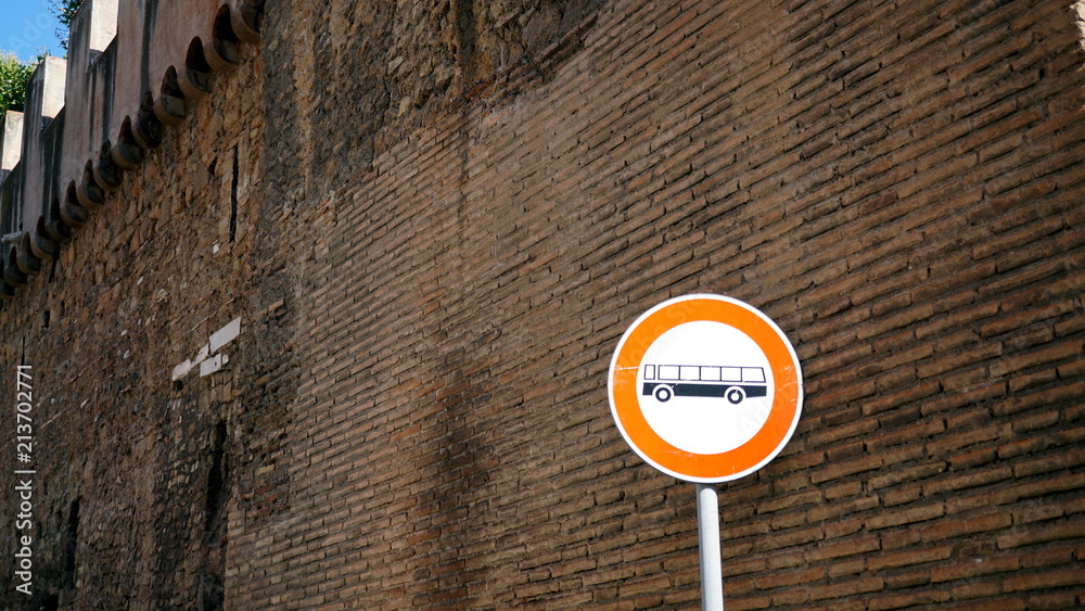 Bus ban prohibition sign in front of an old brick wall, in a sunny day ...