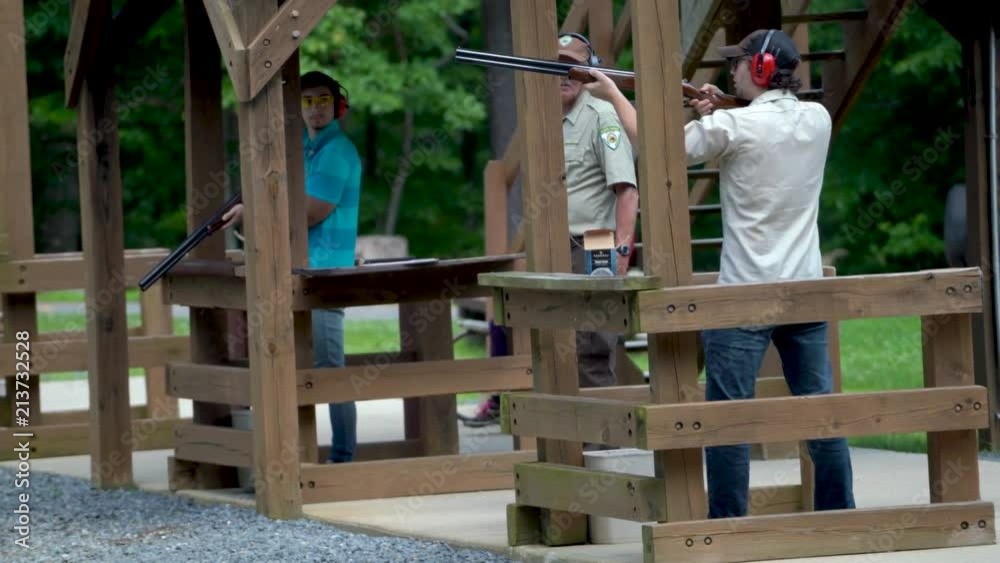 Two wobble range stations in a row with one young man shooting and the ...