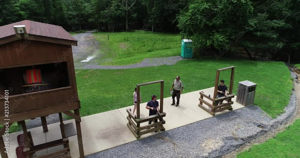 Young man helps his mother practice and learn how to shoot at a wobble ...