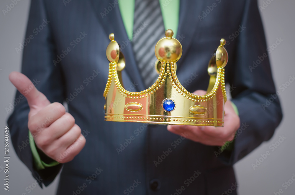 Businessman king holding in hands a gold crown and showing a thumbs up ...