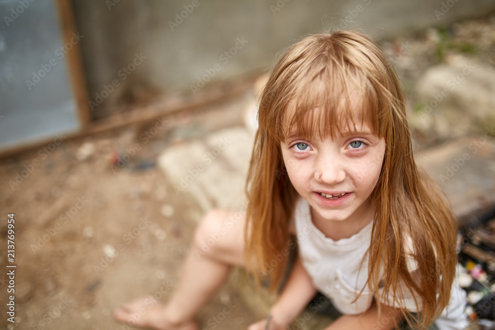 Portrait of tense vulnerable little girl in dirty alley, shallow depth ...