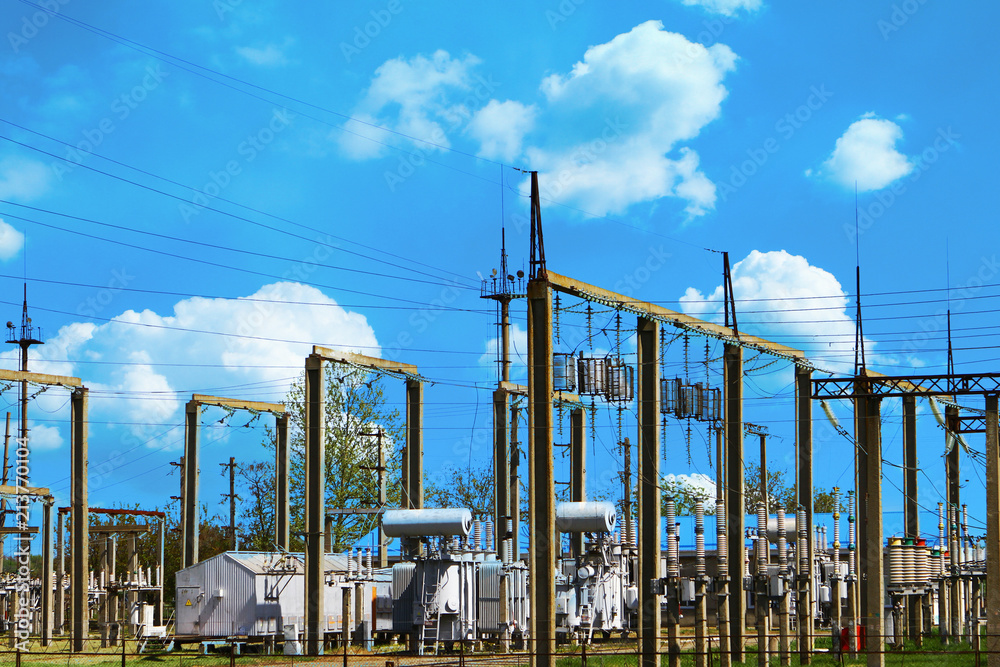 High voltage electric power station - electric poles and lines on blue ...