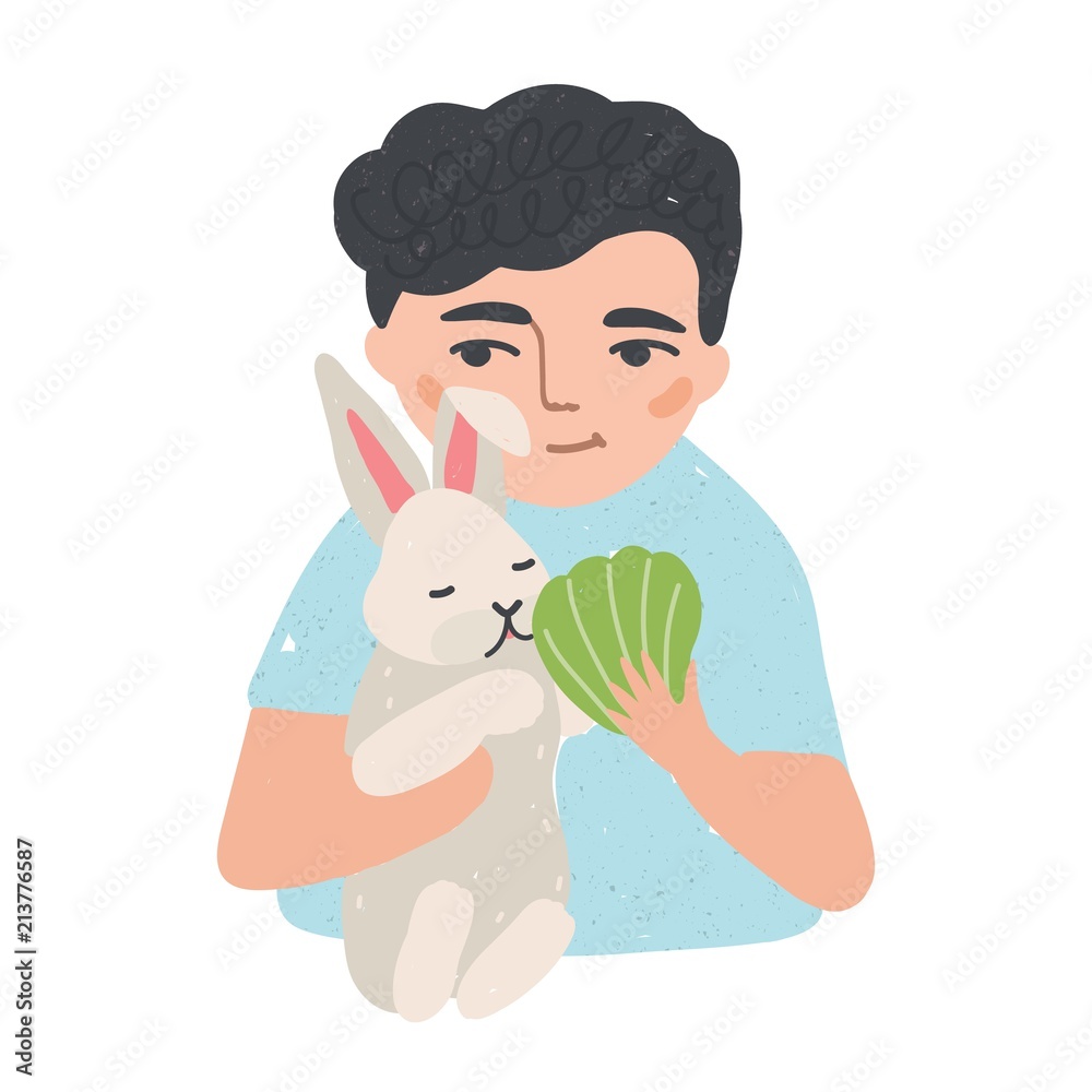 Portrait of young man or boy holding his bunny or rabbit and feeding it ...