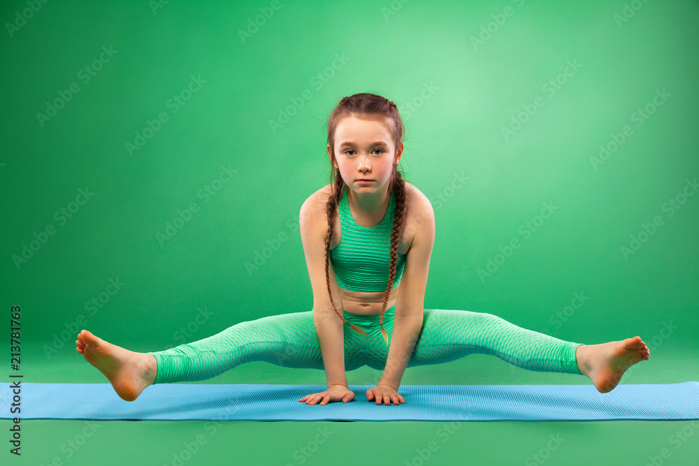 Kid girl doing fitness exercises on green background Stock Photo ...