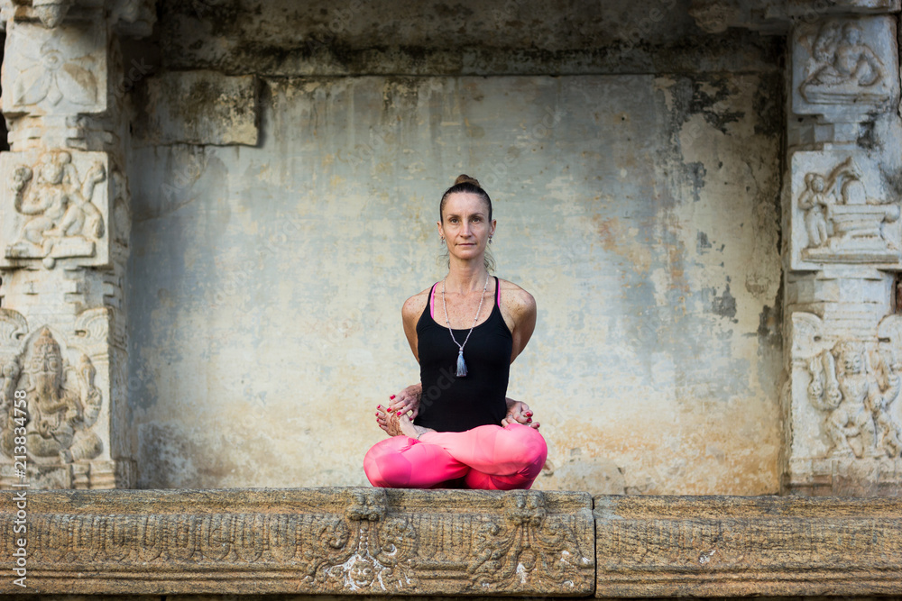 Yogi woman in baddha padmasana pose with pink leggings and hands ...