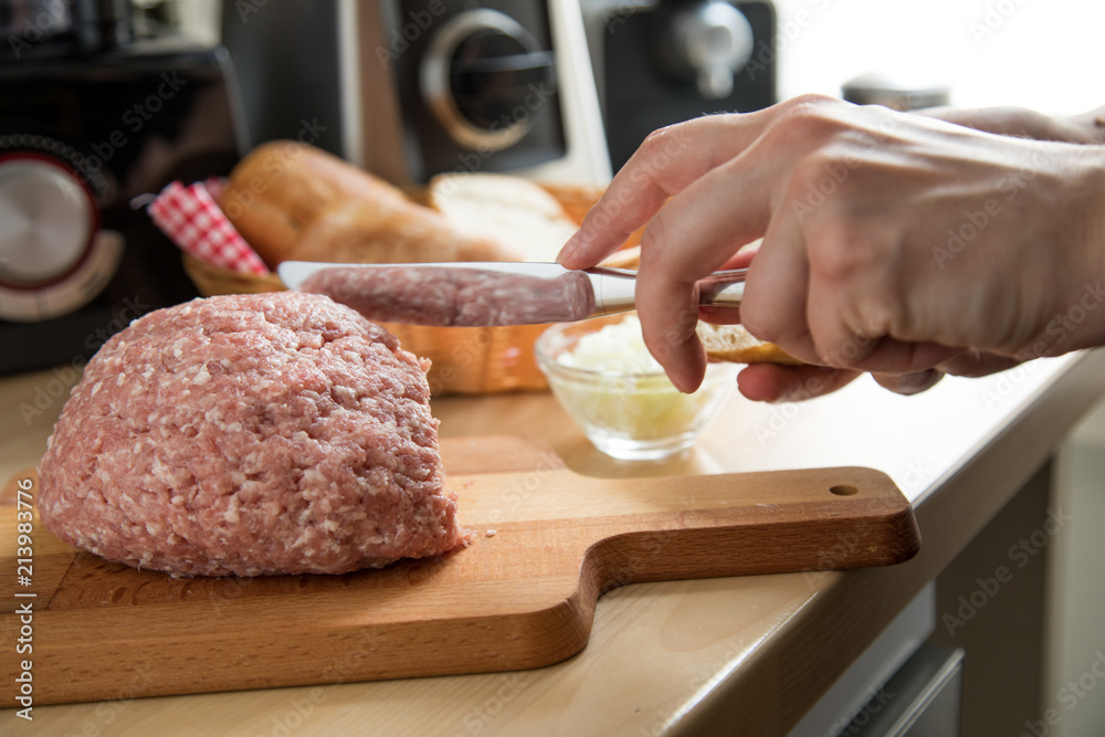 Frau schmiert Mettbrötchen mit Butter und Mett in Küche für Deutsche ...