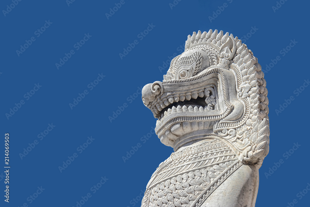 sculpture of ancient white stone singha statue isolated on blue sky ...