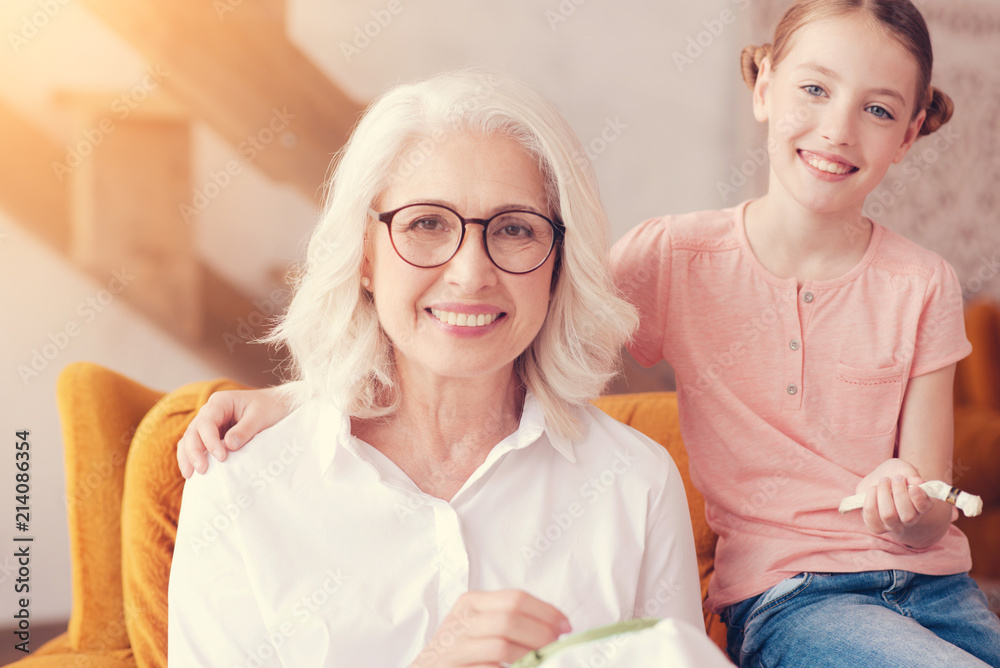 Family ties. Positive minded young lady embracing her beautiful granny ...