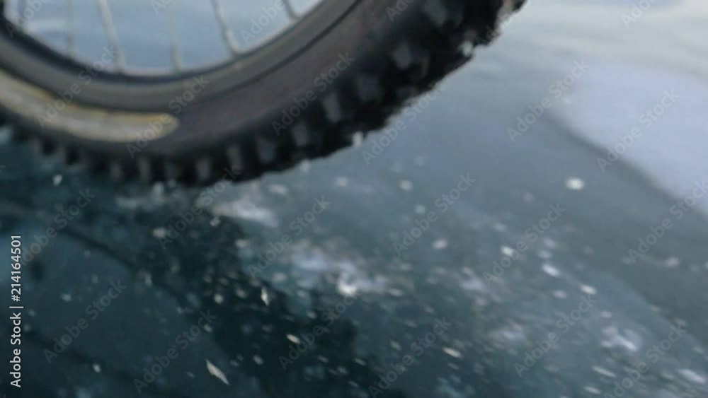 View of the tire. Shooting 180fps. Woman is riding bicycle on the ice ...