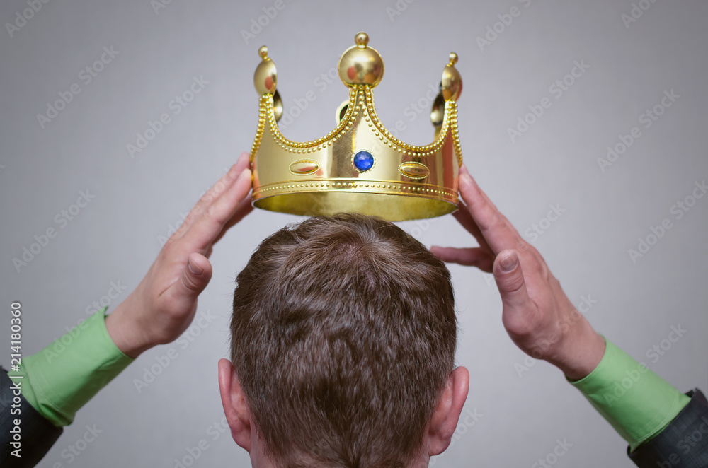 Hands holding a golden crown above a head. Award ceremony of winner ...