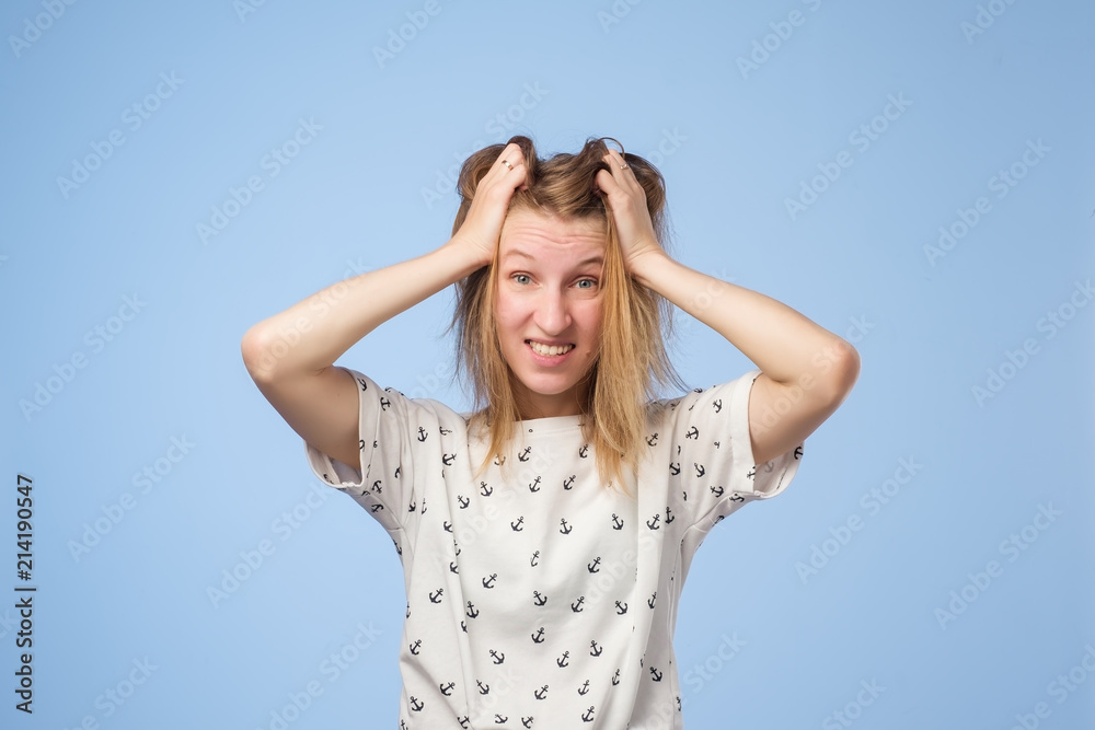 Portrait of a frustrated angry woman screaming out loud and pulling her ...