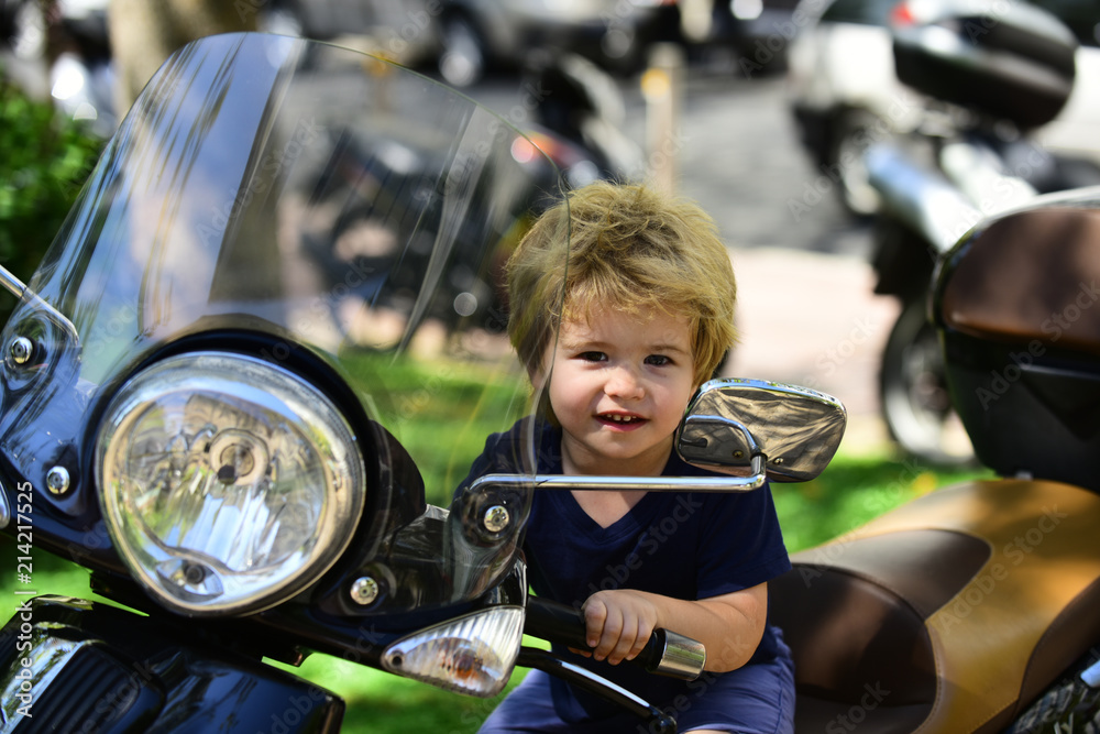 Happy driver on a motorcycle. Young boy during family walk. Little ...