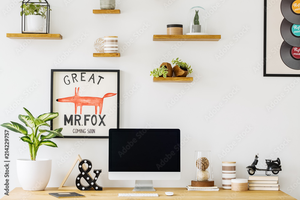 Plant and computer desktop on wooden desk in freelancer's interior with ...