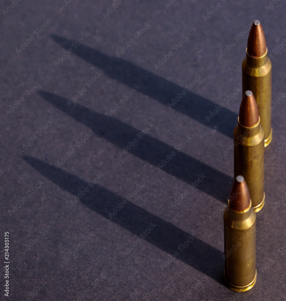 Three high power rifle bullets lined up on a black background with each ...
