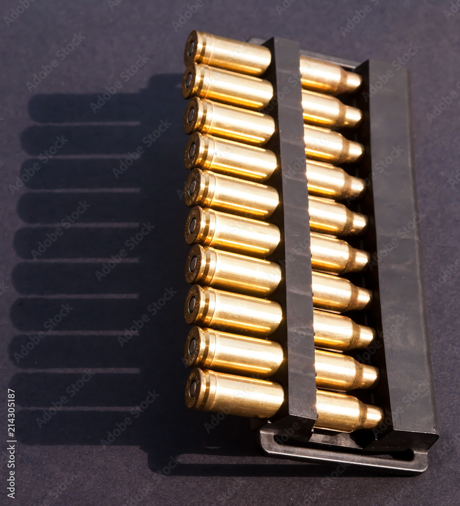 High power hunting bullets in a case on a black background casting a ...