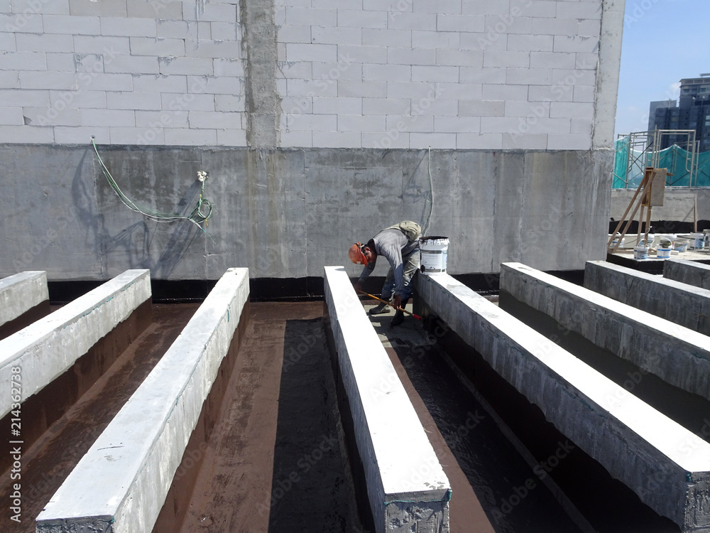 Waterproofing layer applied by construction workers on top of concrete ...