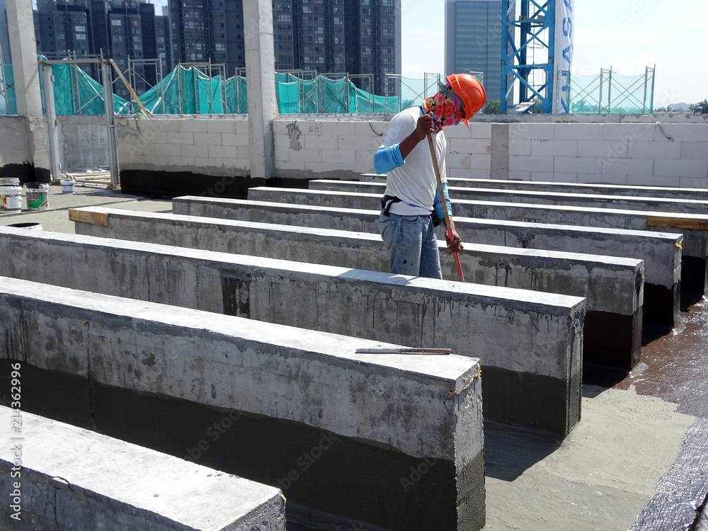 Waterproofing layer applied by construction workers on top of concrete ...