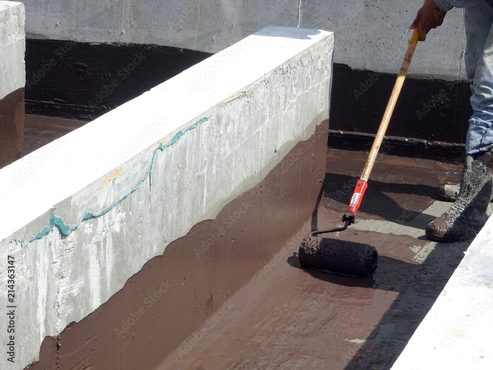 Waterproofing layer applied by construction workers on top of concrete ...