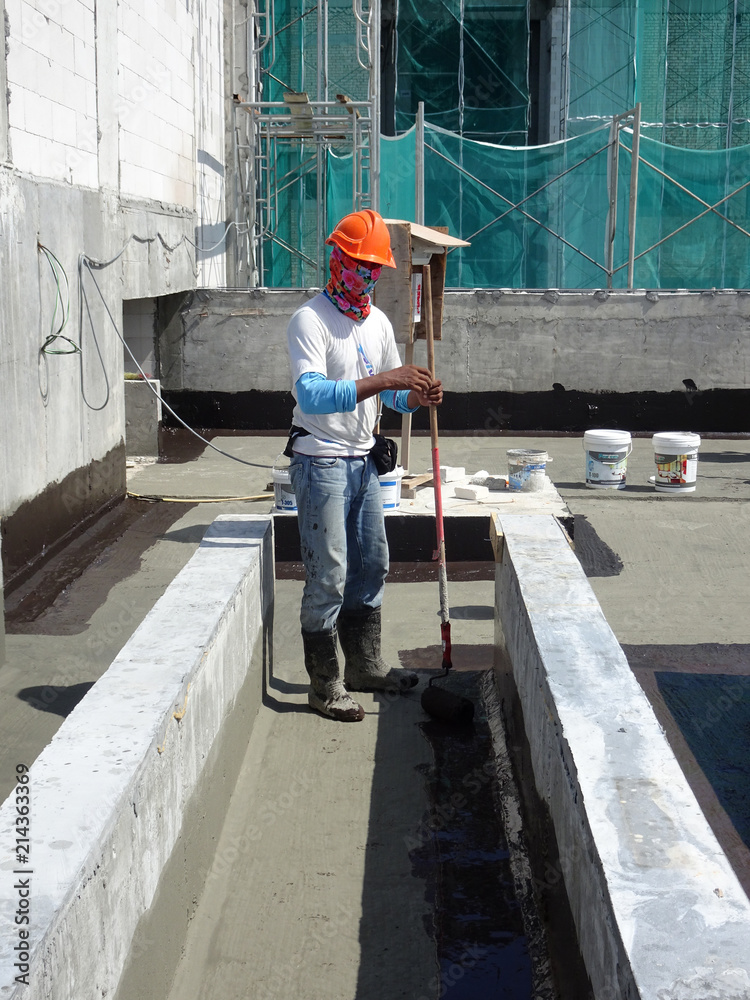 Waterproofing layer applied by construction workers on top of concrete ...