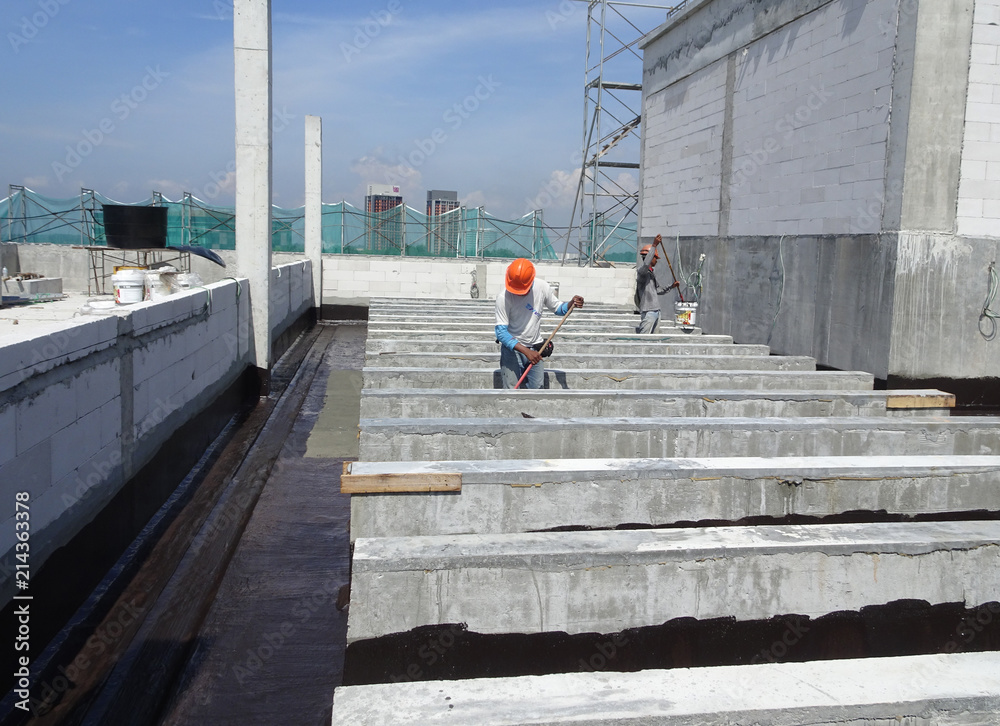 Waterproofing layer applied by construction workers on top of concrete ...