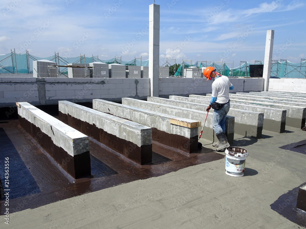 Waterproofing layer applied by construction workers on top of concrete ...