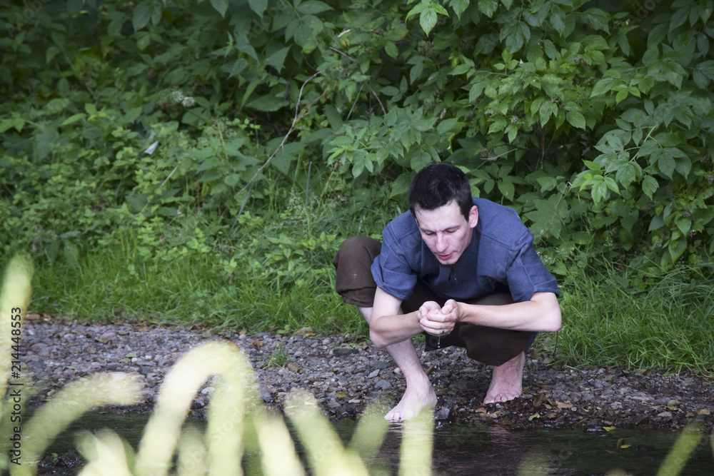 young Celt washes his face on the river and drinking water Stock Photo ...