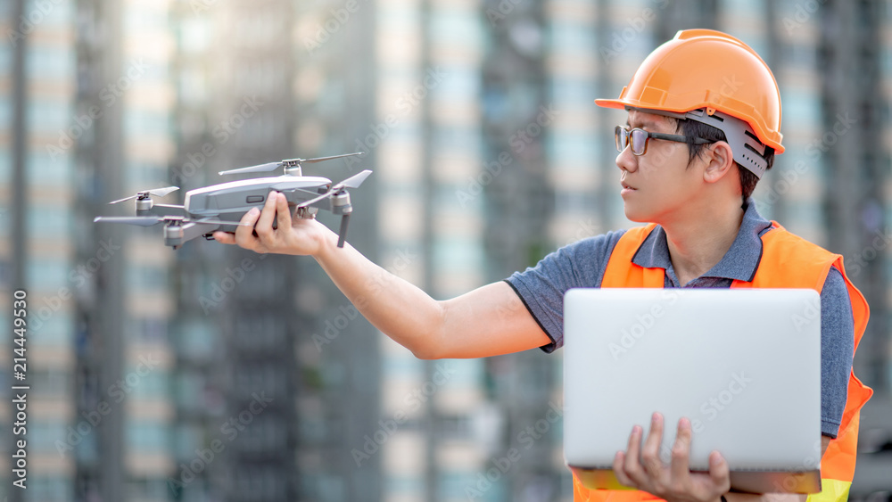Young Asian man working with drone and laptop computer at construction ...