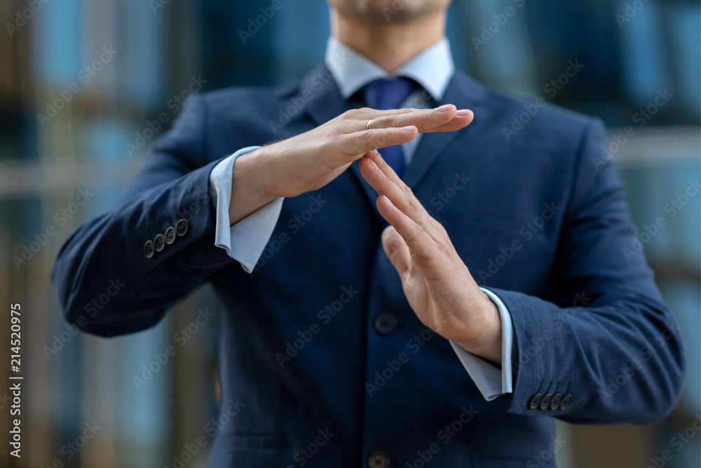 Time-out hand singn made by businessman in blue suit. close up view ...