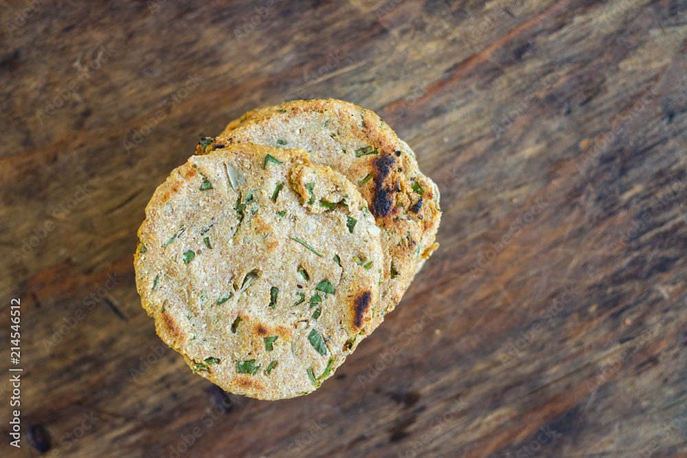 Naan chapati bread with garlic, fresh greens and herbs fried on dry pan ...