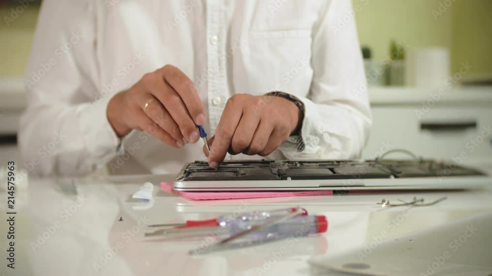 A man is repairing a laptop. The concept of computer repair. Close up ...