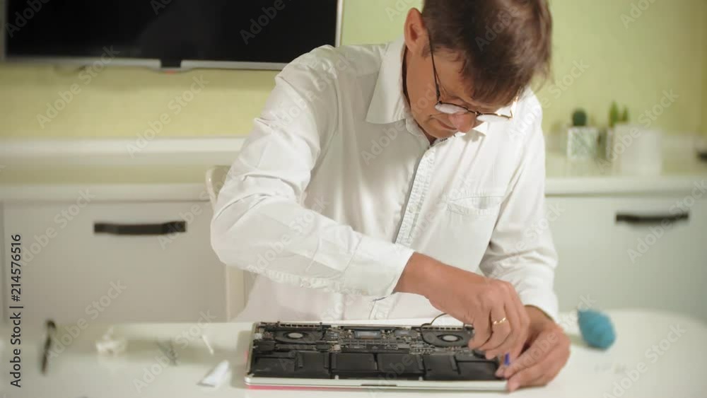 A man is repairing a laptop. The concept of computer repair. Close up ...