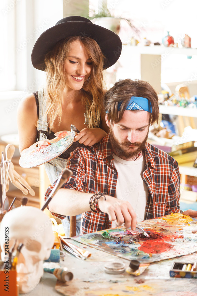 Female long hair artist in cute balck hat and denim dangarees looking ...