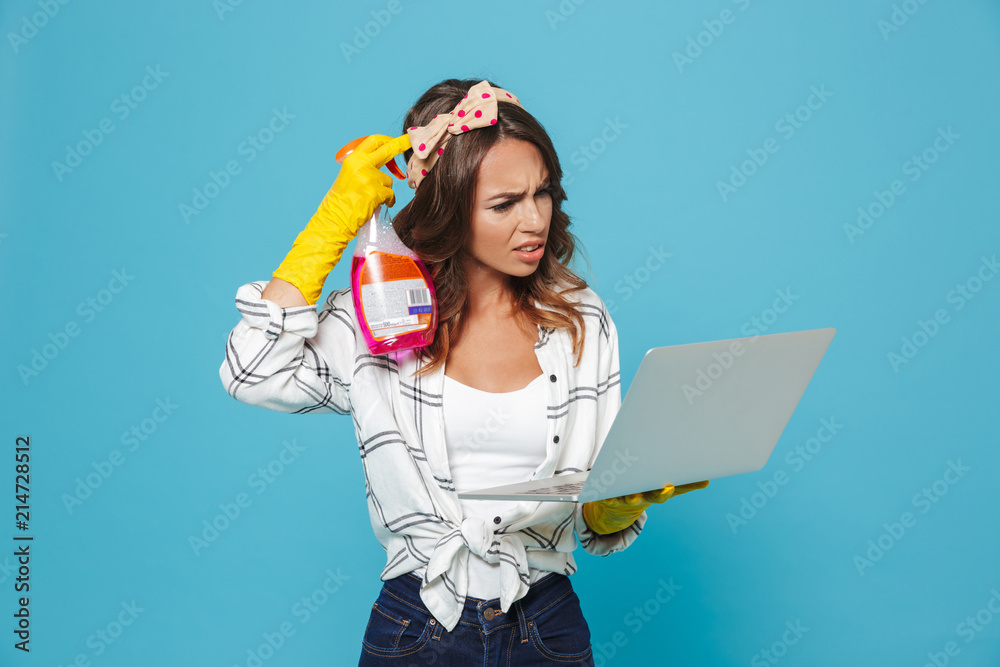 Portrait of puzzled confused housewife 20s in yellow rubber gloves ...