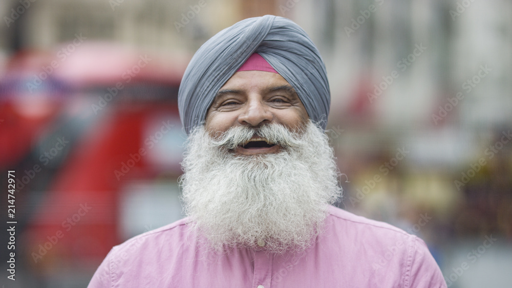Portrait of senior Indian man in a turban smiling to camera on the ...