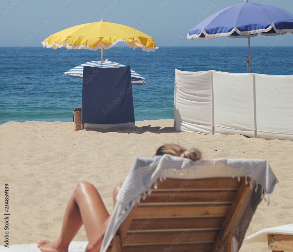 Mulher De Costas Sentada Num Espreguiçadeira De Madeira A Observar O