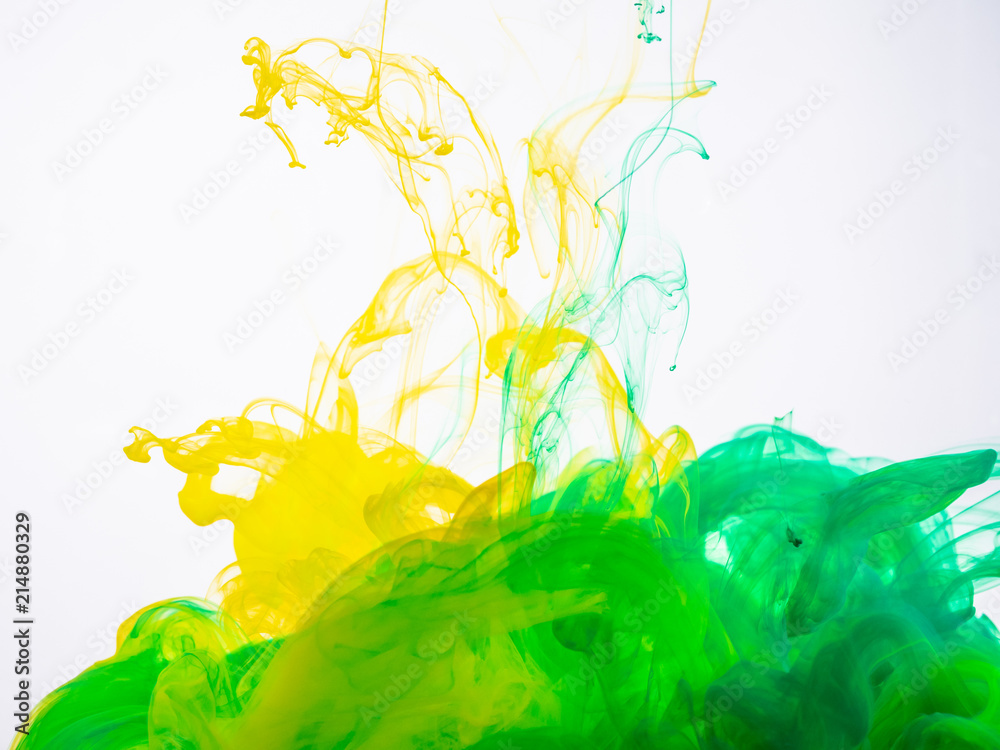 Yellow-green acrylic splash in liquid on white background close up. Two ...