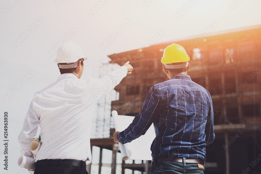Construction engineers discussion with architects at construction site ...